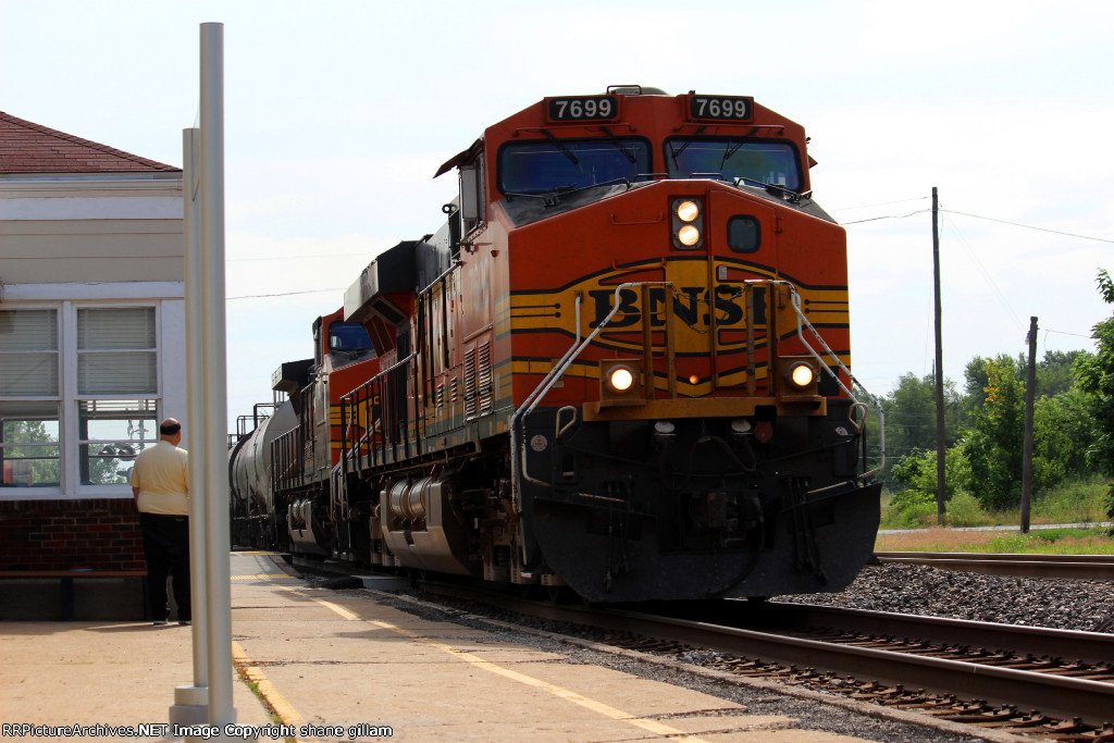 BNSF 7699 leads this freight wb past the depot.